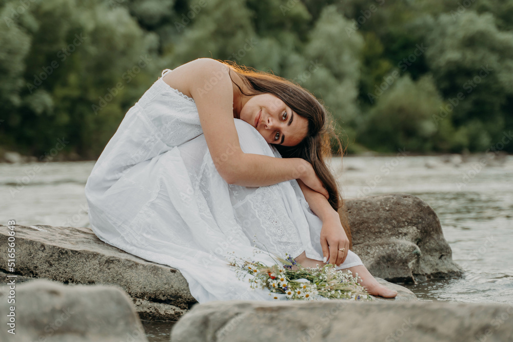 Attractive Girl Sits On Stone With Arms Around Knees And Bowed Head 8156