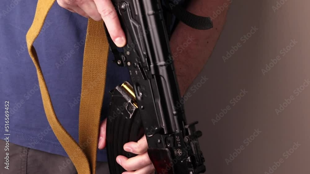 Man attaches ak-47 magazine with cartridges and reloads Kalashnikov ...