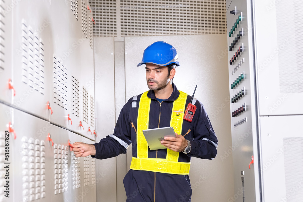 Maintenance engineer inspect relay protection system with laptop tablet ...