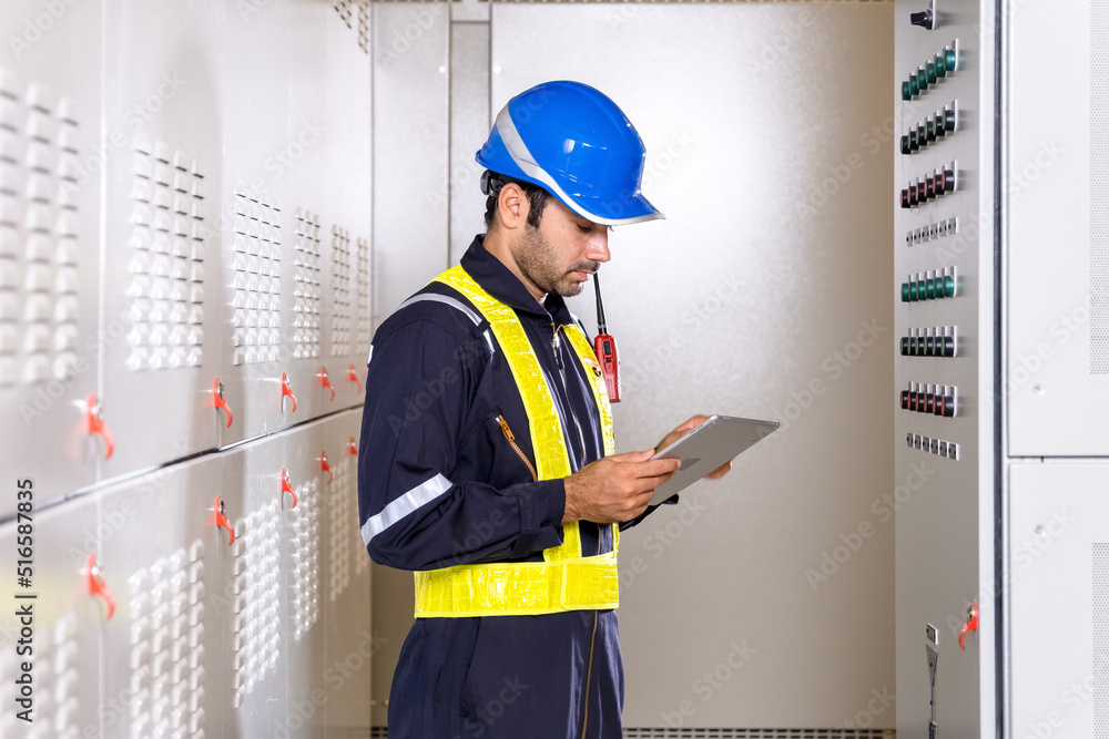 Maintenance engineer inspect relay protection system with laptop tablet ...