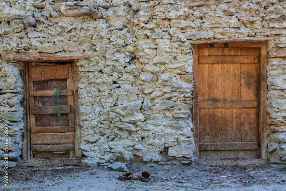 Wooden door and stone wall. Traditional house exterior of the village ...