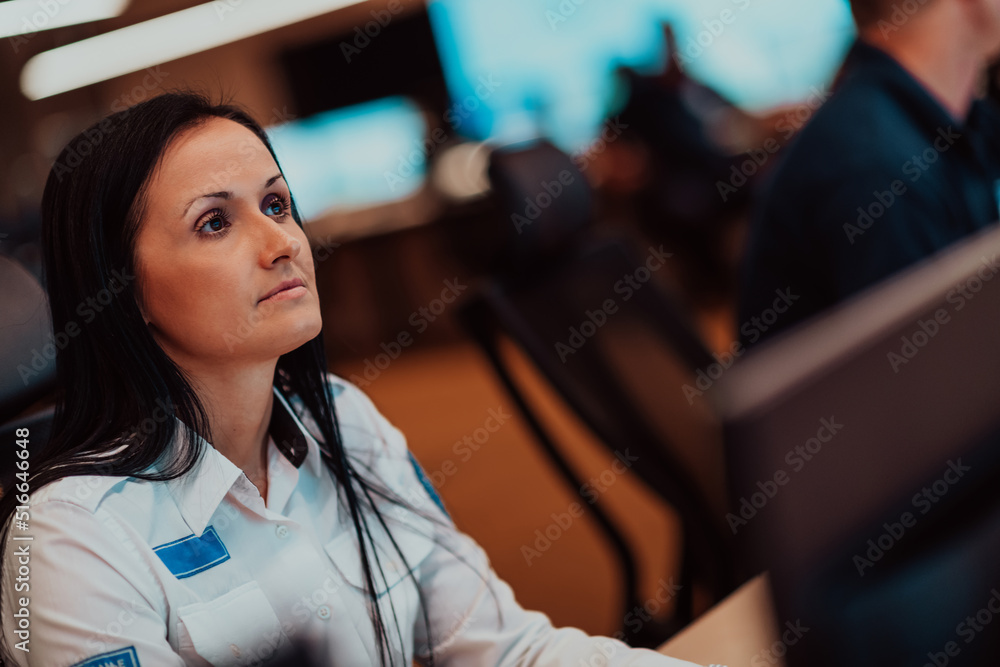 Female security operator working in a data system control room offices ...