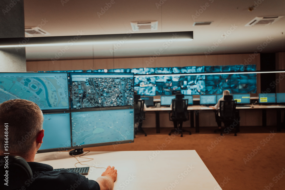 Male security operator working in a data system control room offices Technical Operator Working ...