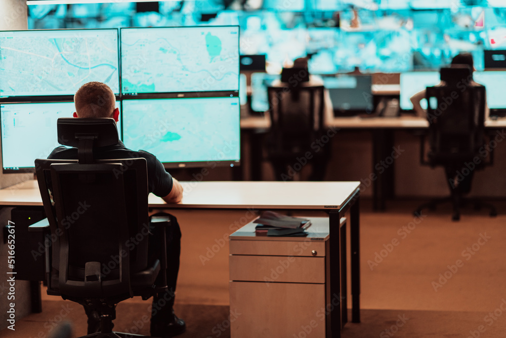 Male security operator working in a data system control room offices ...