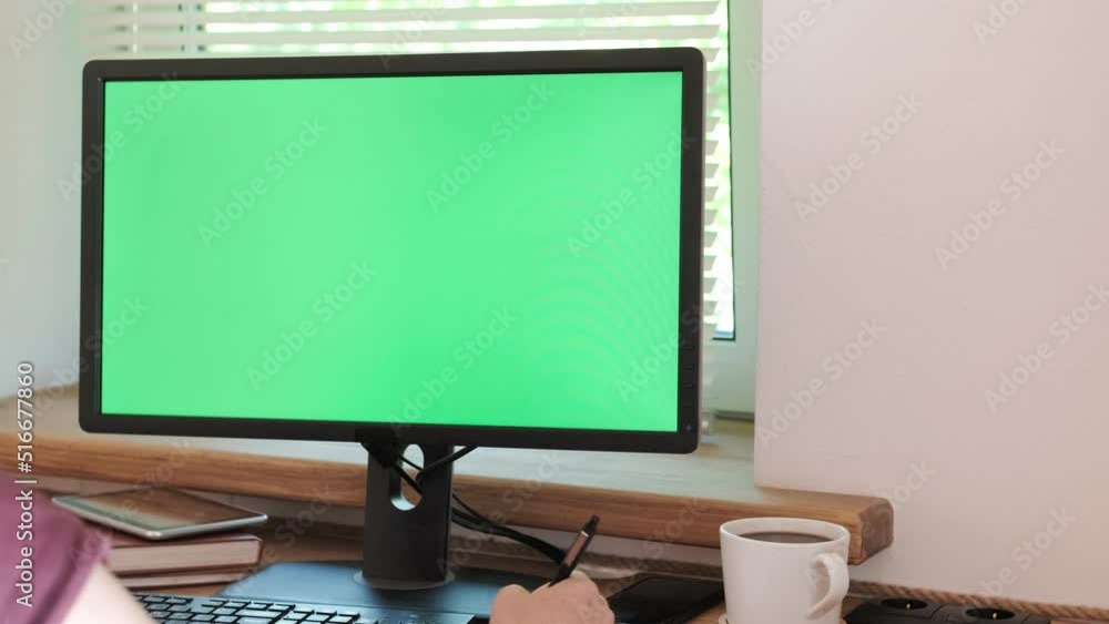 Corporate employee using computer with horizontal green screen for ...