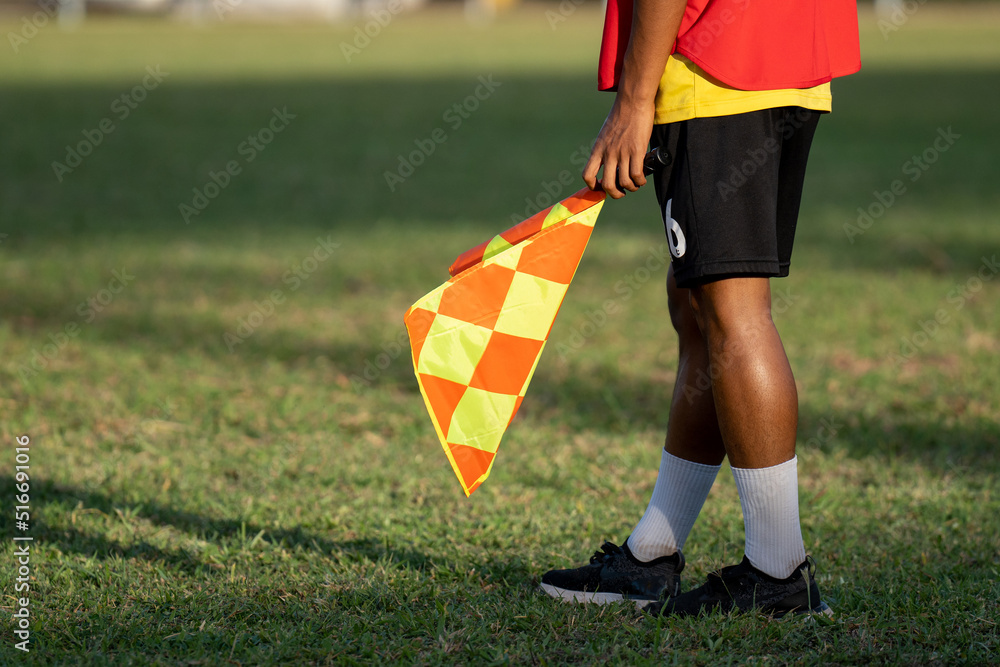 Lineman or Assistant referee of football or soccer holding flag in ...