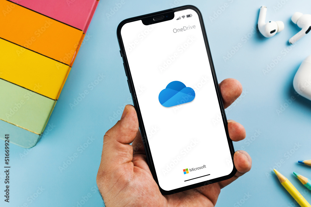 Man holding a smartphone with Microsoft Onedrive cloud storage app on ...