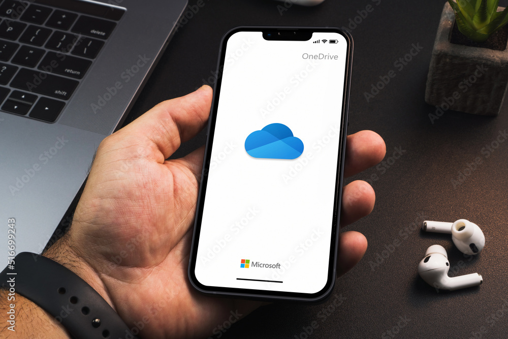Man holding a smartphone with Microsoft Onedrive cloud storage app on ...