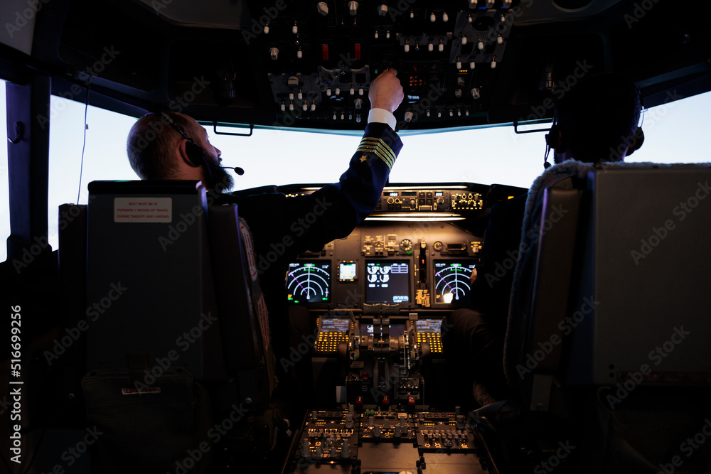 Aircraft captain pushing dashboard handle in plane cockpit, flying ...