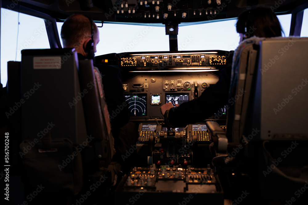 Team of aircrew members throttling engine to fly airplane, using control panel command in pilot ...