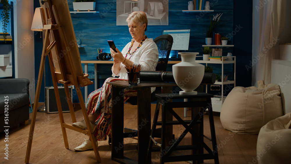 Retired woman drawing authentic vase model on canvas and taking ...