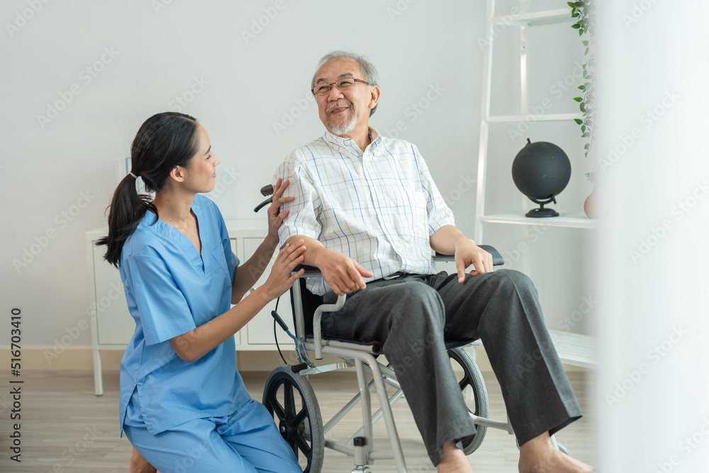 Young Asian woman caregiver doctor during home visit talking encourage to senior elderly patient ...