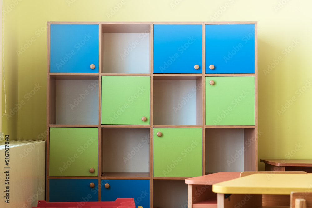 Multi colored wooden cabinet with cells stands in empty classroom ...
