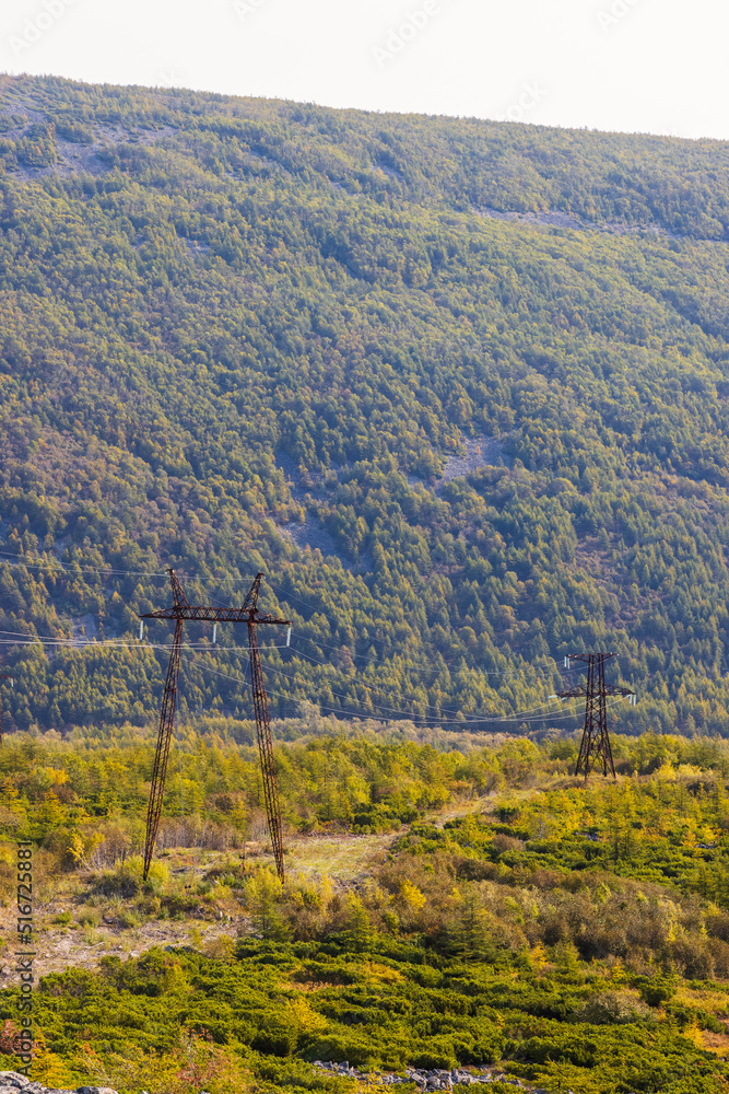 Power line in the mountains. Large metal electric pylons on mountain ...