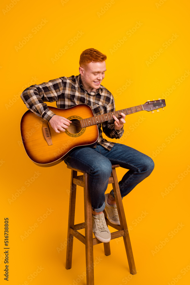 Full size photo of young handsome man sit stool play guitar performance ...