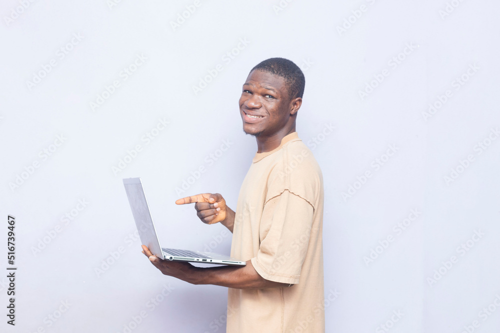 Young black delighted African guy holding point at laptop with one ...