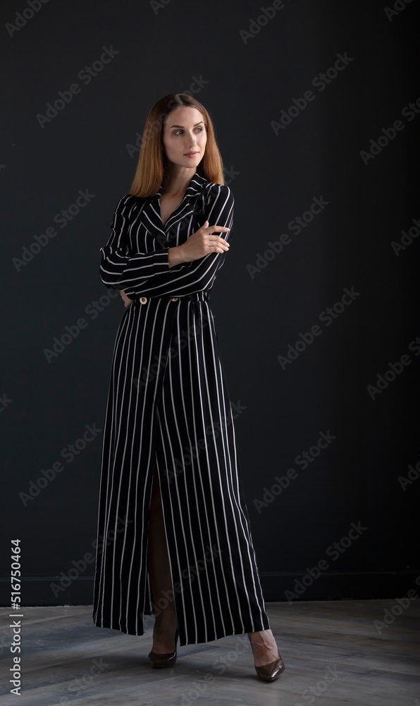 young girl with a slim figure in a black and white striped dress, full ...