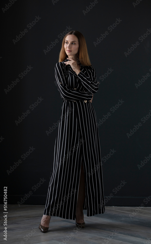 young girl with a slim figure in a black and white striped dress, full ...