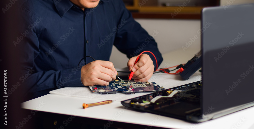 young man who is a computer technician A laptop motherboard repairman ...