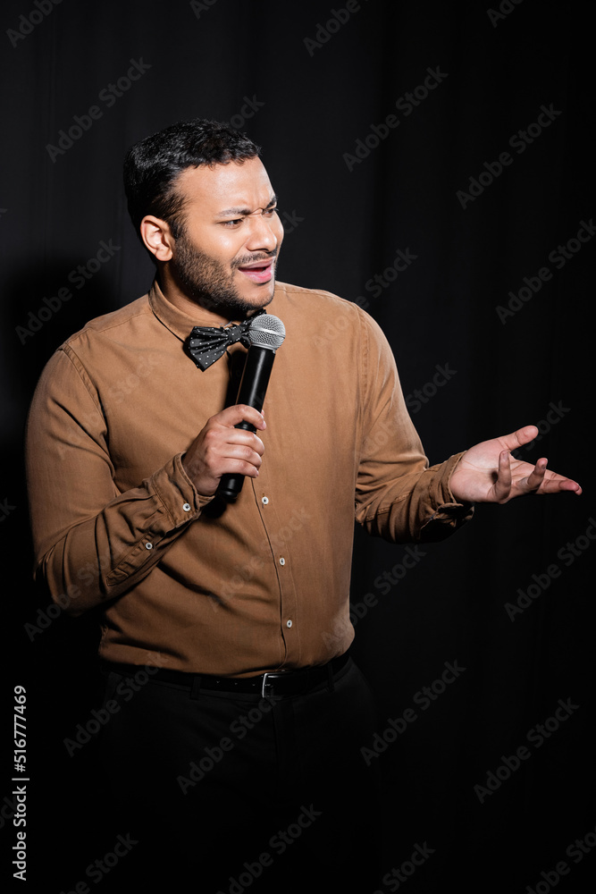 Displeased Indian Stand Up Comedian In Shirt And Bow Tie Holding