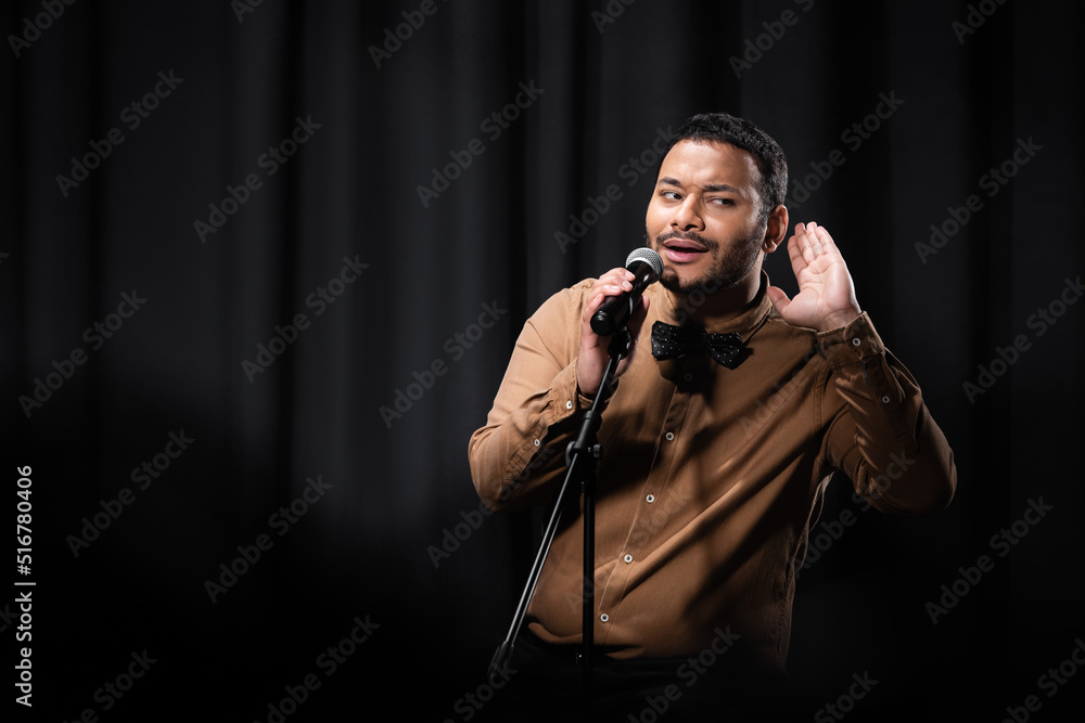 indian comedian listening during stand up comedy show on black. Stock ...