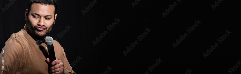 skeptical indian stand up comedian telling joke into microphone and ...