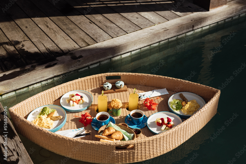 Breakfast in swimming pool, floating breakfast set in tray in resort ...