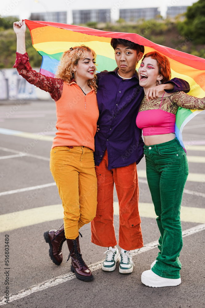 Happy diverse people having fun together at LGBT pride parade holding ...