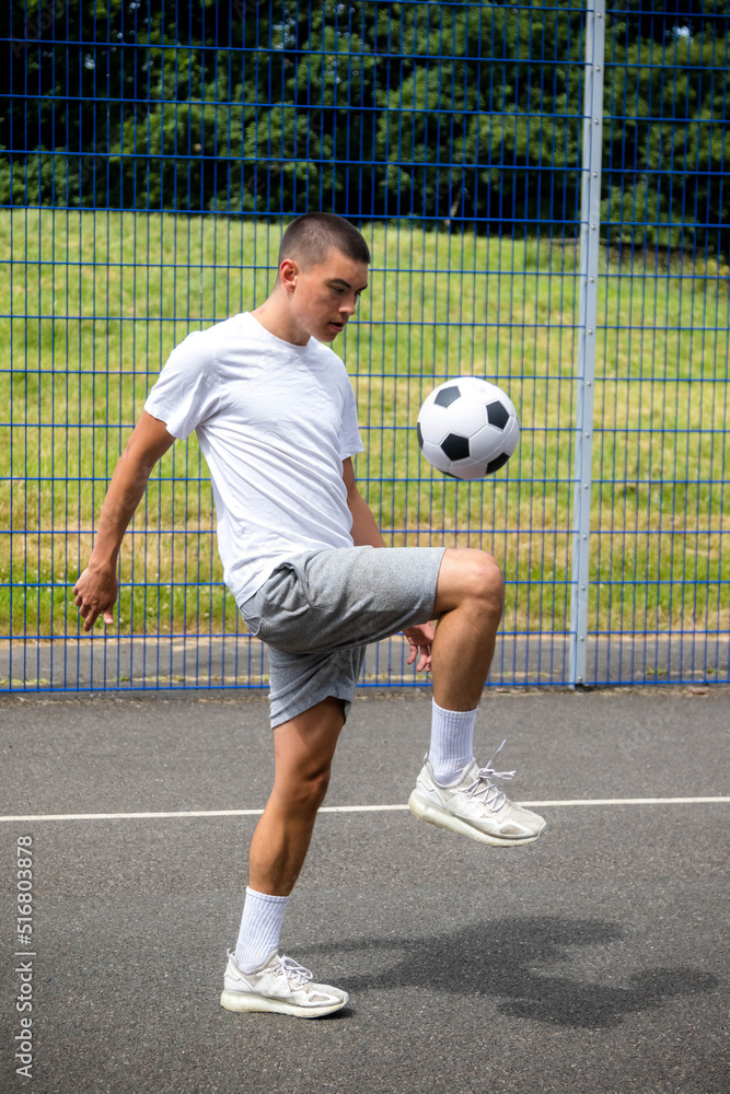A Nineteen Year Old Teenage Boy Playing Football in A Public Park Stock ...