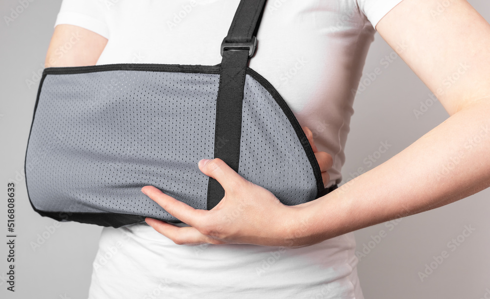 Woman wearing sling to protect painful forearm, wrist. Arm trauma ...