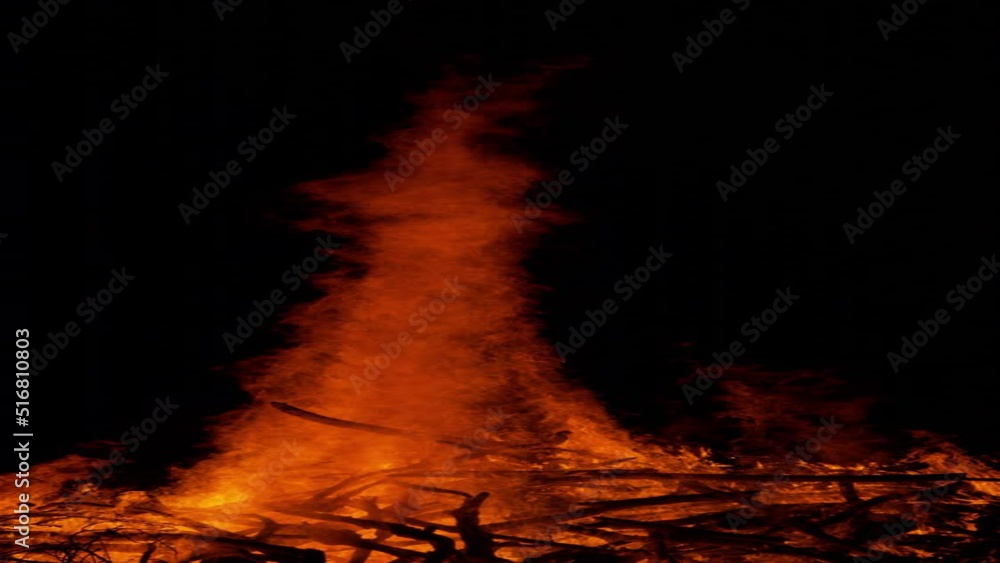 SLOW MOTION, VERTICAL: Fiery flames reach up into the pitch black of a ...