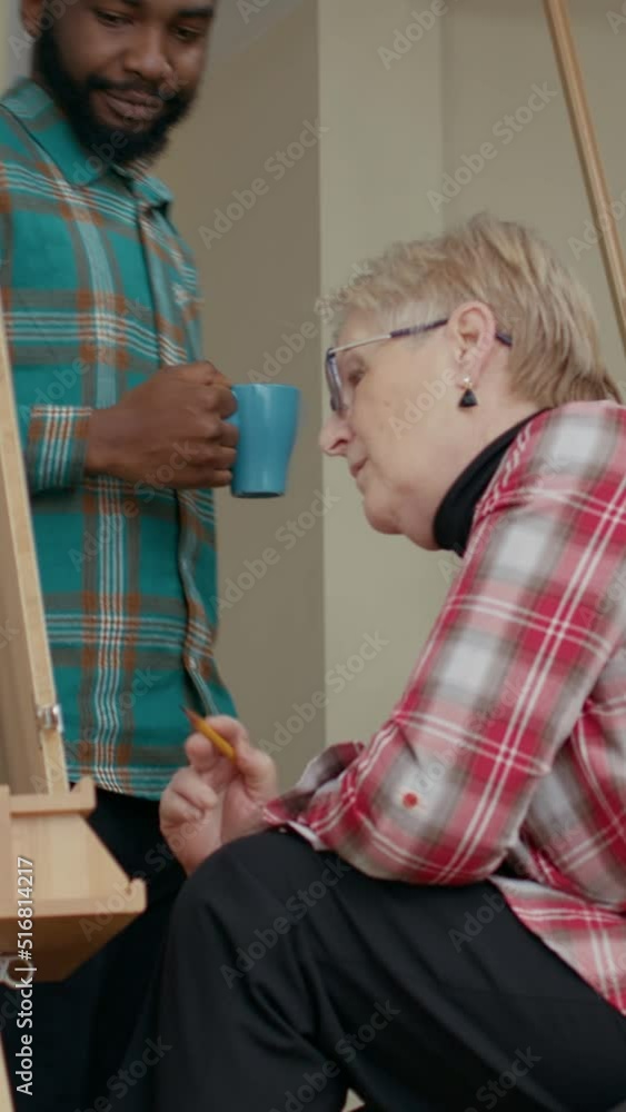 Vertical video: African american teacher guiding senior woman to draw ...