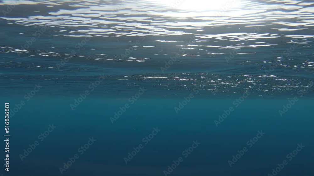 VERTICAL UNDERWATER, SLOW MOTION, LENS FLARE: Bright summer sunbeams ...