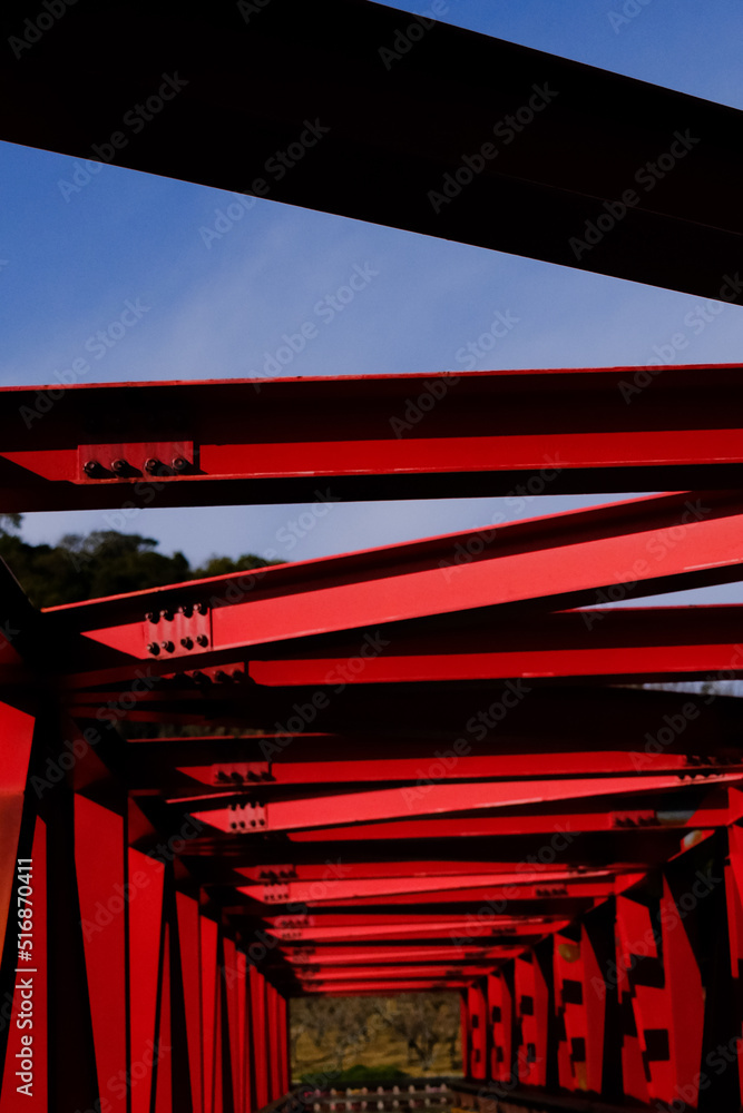 Red metal bridge tower with blue sky background. Pattern and design ...