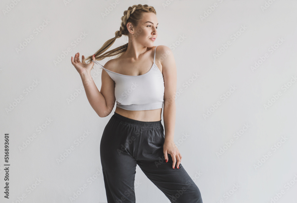 attractive young blond woman with curves posing after a workout in a ...