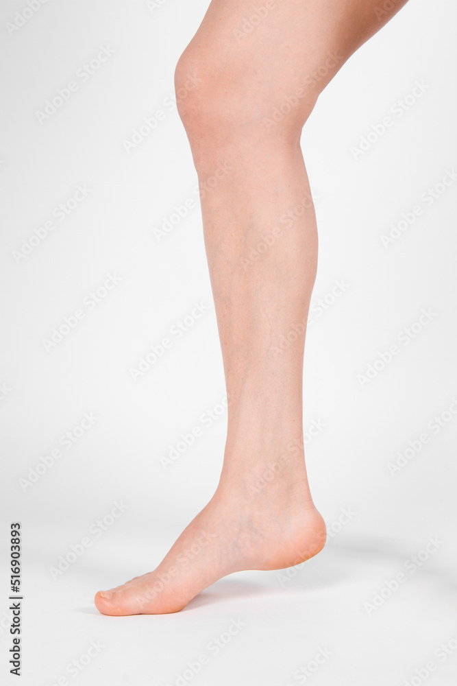 Barefoot and legs isolated on white background. Closeup shot of healthy beautiful female feet ...