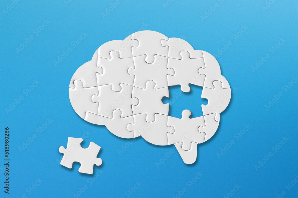 Brain shaped white jigsaw puzzle on blue background, a missing piece of ...