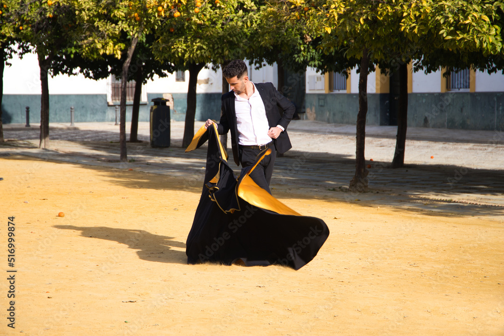Portrait of young and handsome gipsy man, dressed in black and red shoes dancing with a black ...