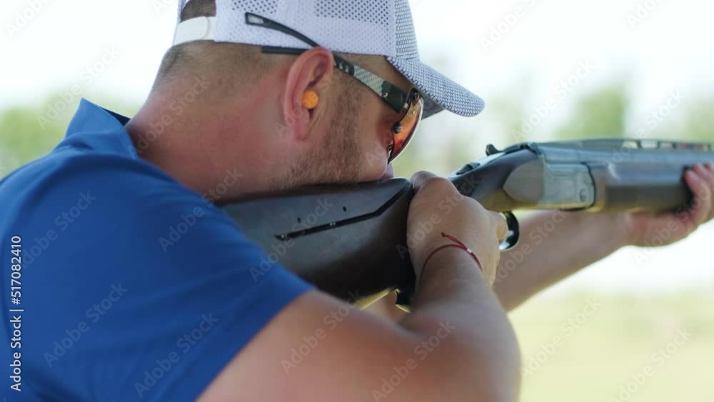 Sportsman shoots from a double-barreled shotgun, A sports field for a ...