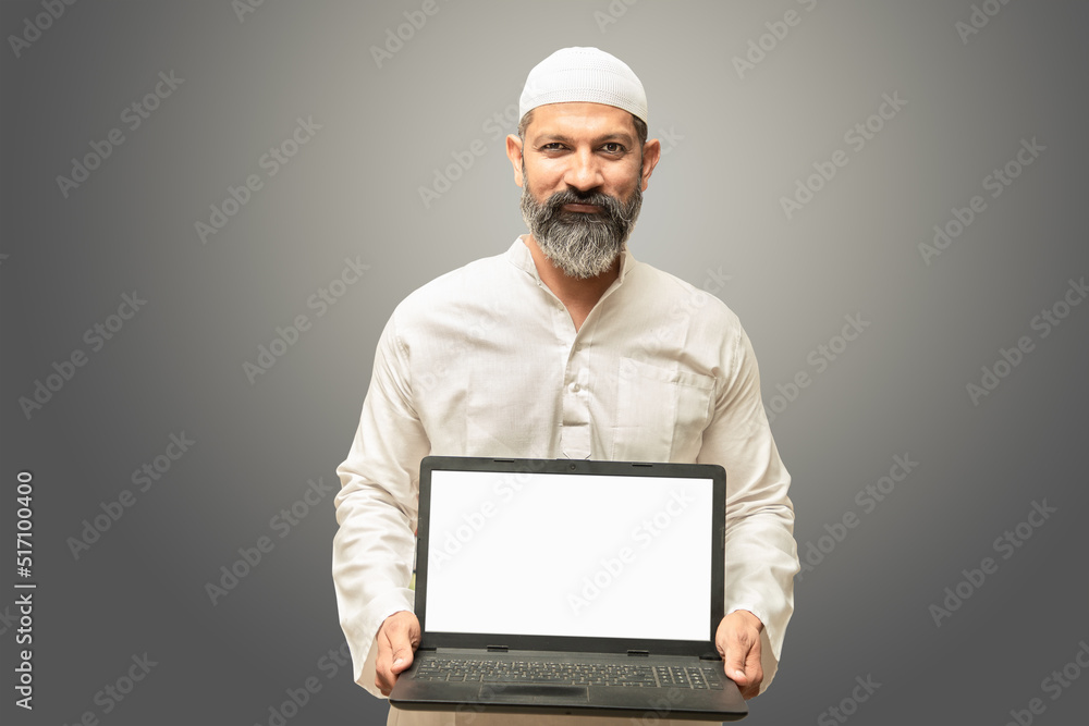 Happy asian indian muslim man showing laptop with white or blank screen ...