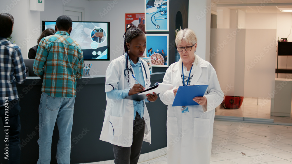 Old medic and african american physician analyzing checkup papers in ...