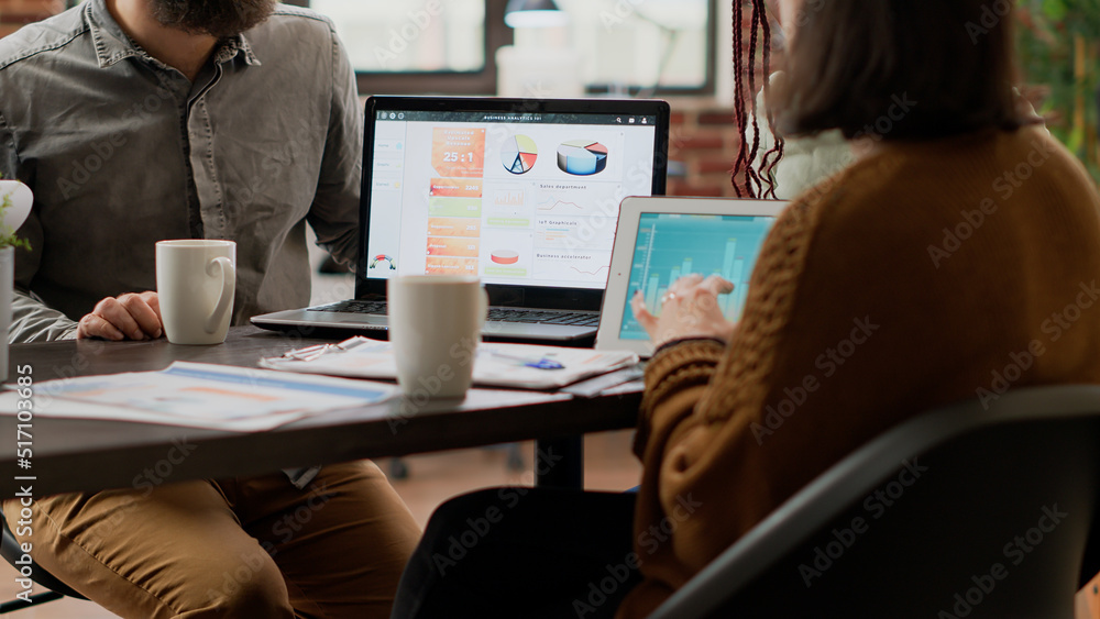 Multiethnic group of colleagues working on charts analysis with digital ...