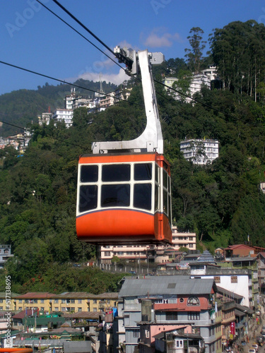 Obraz na płótnie The cable car passing above the houses vehicles on the ...