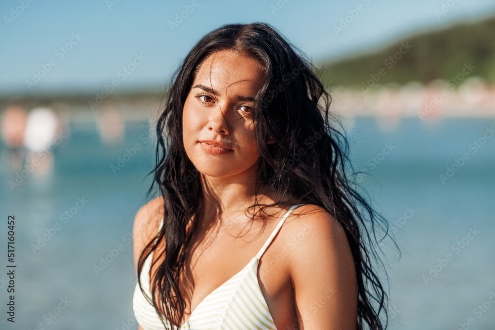 Foto de people, summer and swimwear concept - beautiful young woman in bikini swimsuit on beach ...