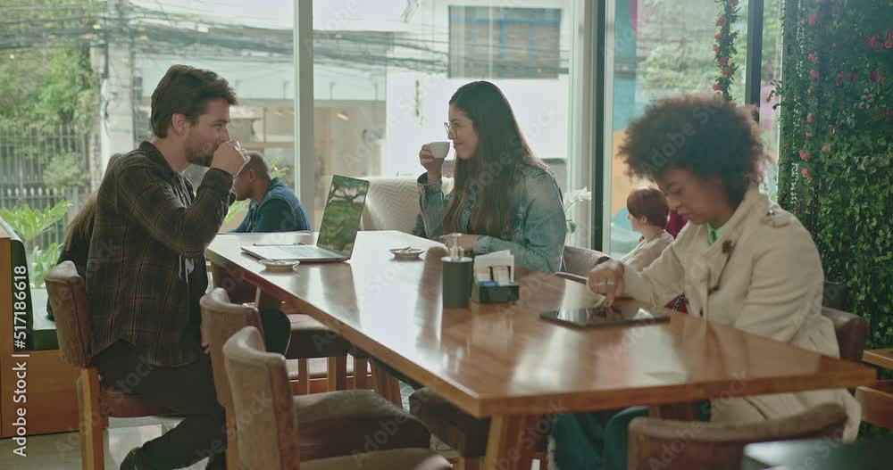 People sitting inside coffee shop drinking cafe. Local business ...