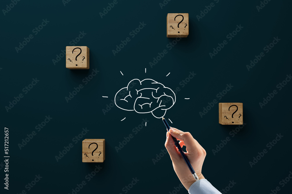 Wooden blocks with a question mark icon and a drawn brain. Concept of ...