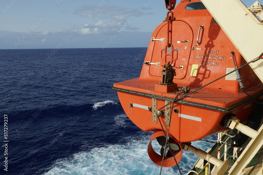 View on the aft part of orange colour lifeboat with reflective tape ...