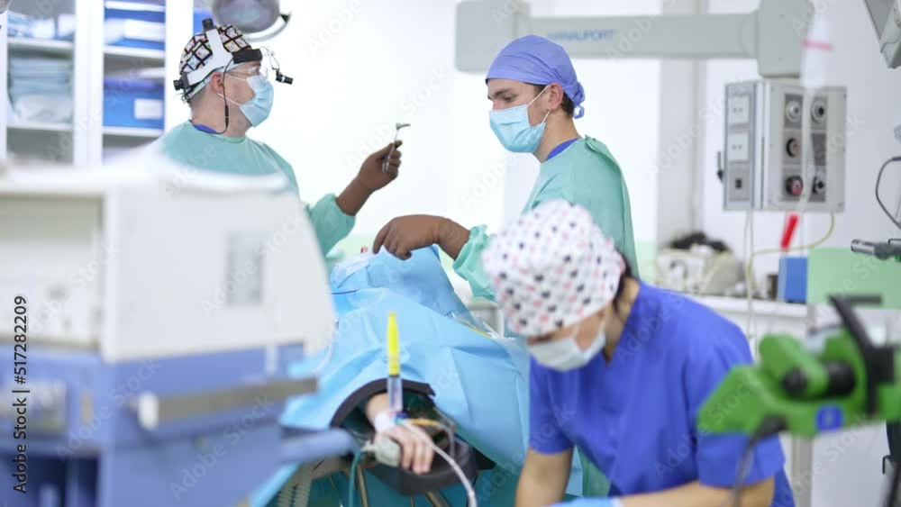 Female nurse inputs medicines into tubes connected to patient’s hand ...