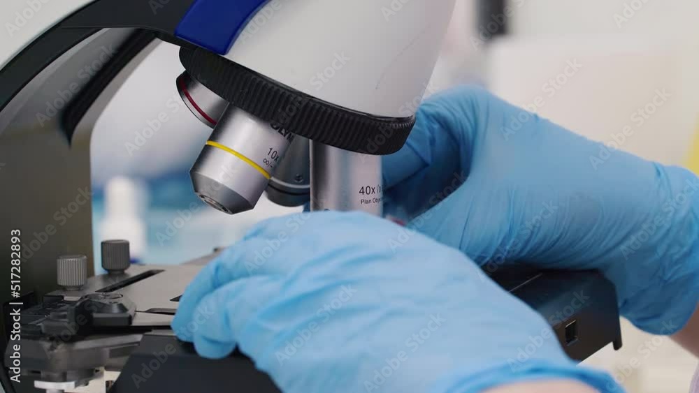 Doctor uses the examination microscope tool to study the illness ...