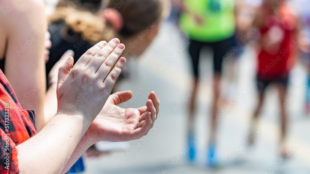 Clapping hands of an unrecognizable woman at an athletics marathon ...